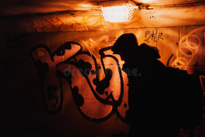 A Silhouette of a Man Passing in a Dark Red Rusty Tunnel with Dim ...