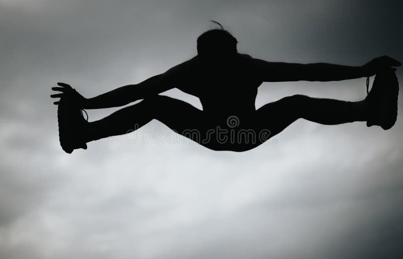 Silhouette of Man Practicing High Jumps Against Cloudy Sky Backdrop ...