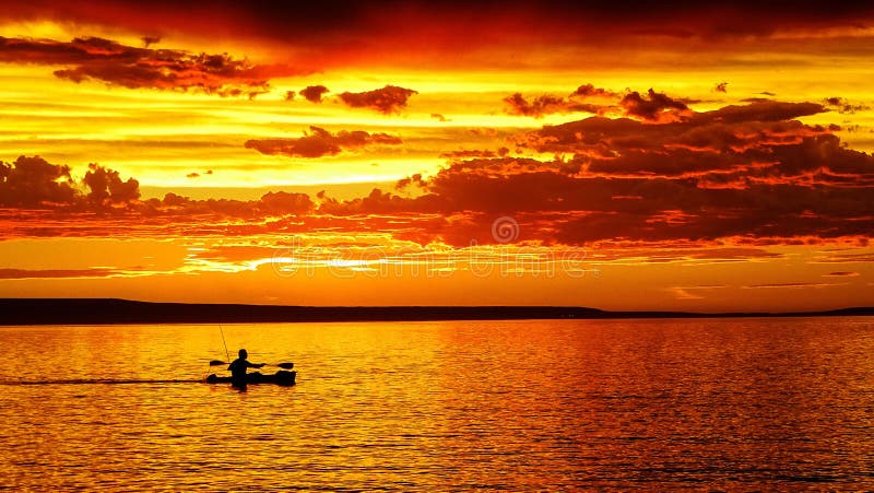 Silhouette of a Man Rowing in a Golden Sunset Stock Photo - Image of ...