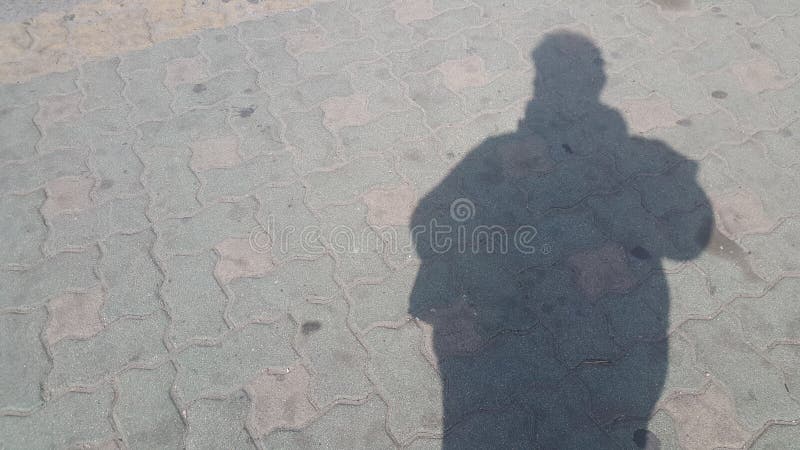 A Man`s Shadow on the Red Colored Concrete Ground Stock Photo - Image ...