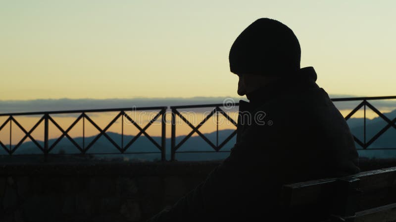 Silhouette of a Man Sitting on Bench Watching Time Pass after ...
