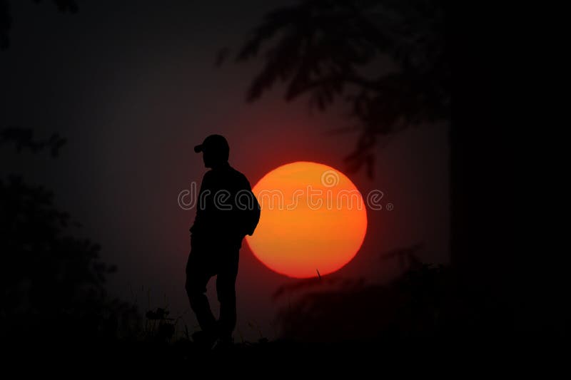 Silhouette of Man Standing at Sunset in Nature. Big Round Sun in ...