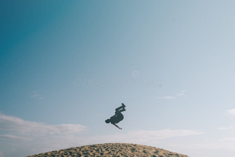 Silhouette of a Men Doing an Acrobatic Backflip Move on Sand Dunes ...