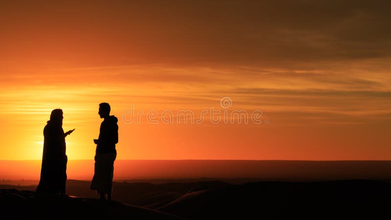Silhouette of Men Standing in the Desert at Sunset Stock Photo - Image ...