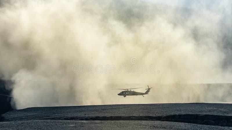 Silhouette of Military Helicopter Landing or Taking Off in a Dust Cloud ...