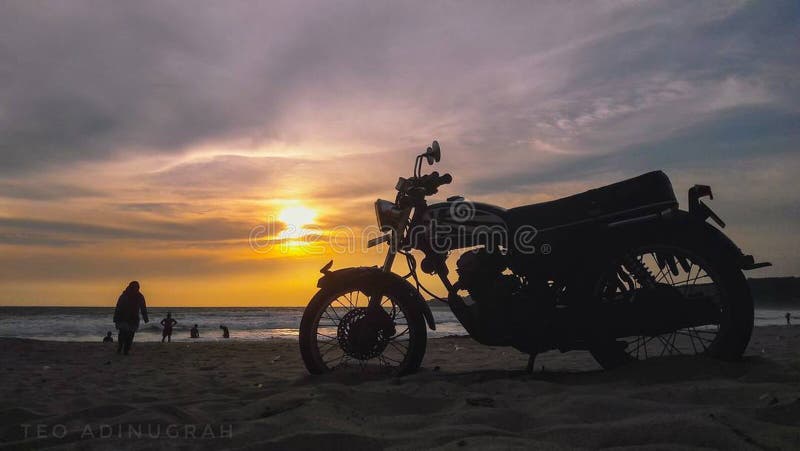 Silhouette of a Motorcycle on the Beach at Sunset in the Evening ...