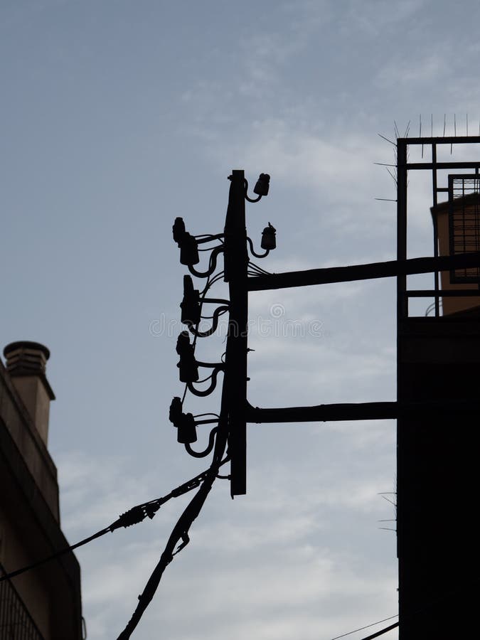 Silhouette of an Old Electric Pole Hanging on a Building Against the ...