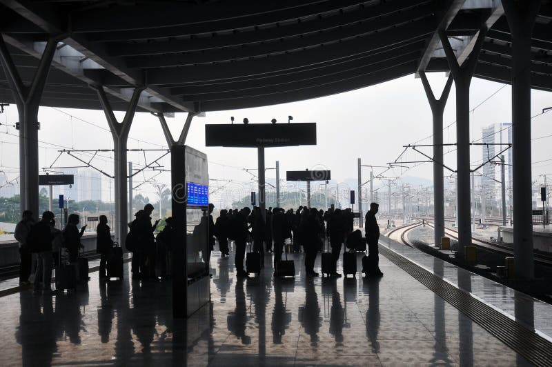 Silhouette of People Line Up and Wait for Train Inside Railway Station ...