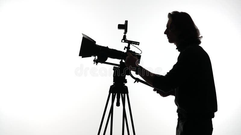 Silhouette of a Person Adjusting Camera on Tripod Setup Stock Footage ...