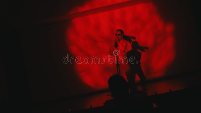 Silhouette of a Person Performing on Stage with Dramatic Red Lighting ...