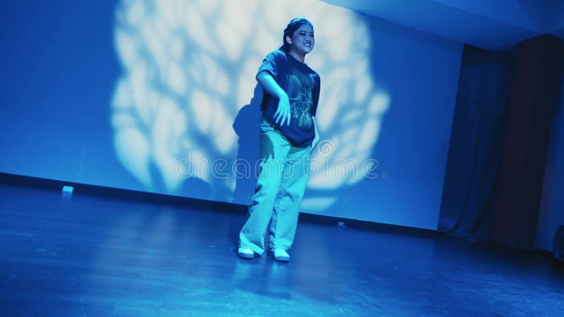 Silhouette of a Person Standing in a Blue-lit Room with Artistic Shadow Patterns on the Wall ...
