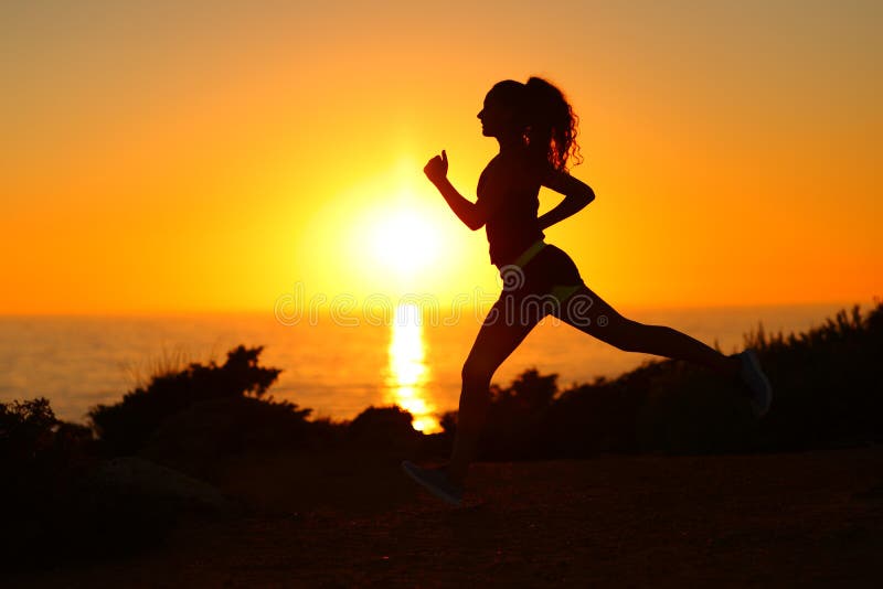 Silhouette of a Runner Running at Sunset on the Beach Stock Photo ...