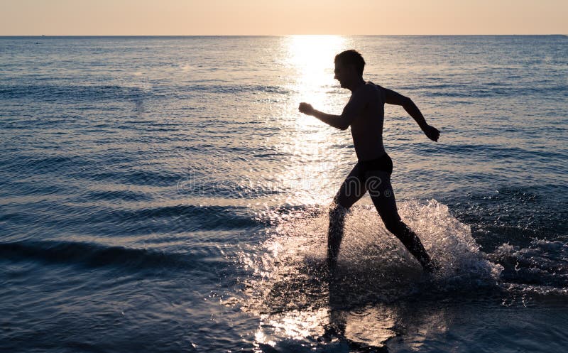 Silhouette of Running Man in Water of Sea Stock Photo - Image of sport ...