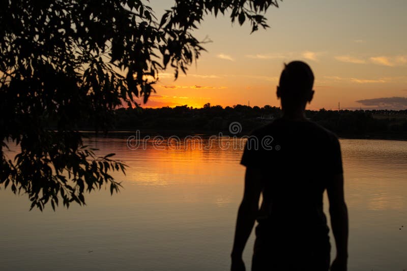 Silhouette Shot of a Man Standing and Looking at the Gleaming Yellow ...
