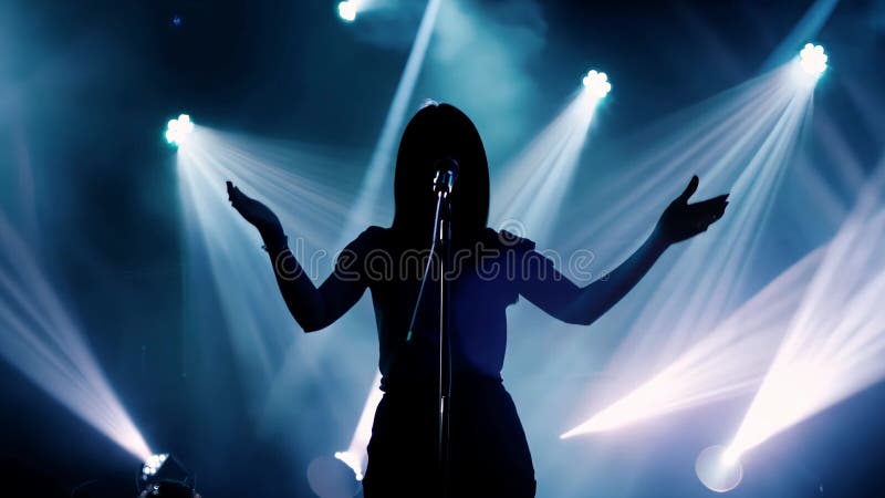 Silhouette of Singer Performing on Stage with Dramatic Lighting and ...