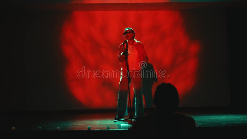 Silhouette of a Singer on Stage with Dramatic Red Lighting and Abstract ...