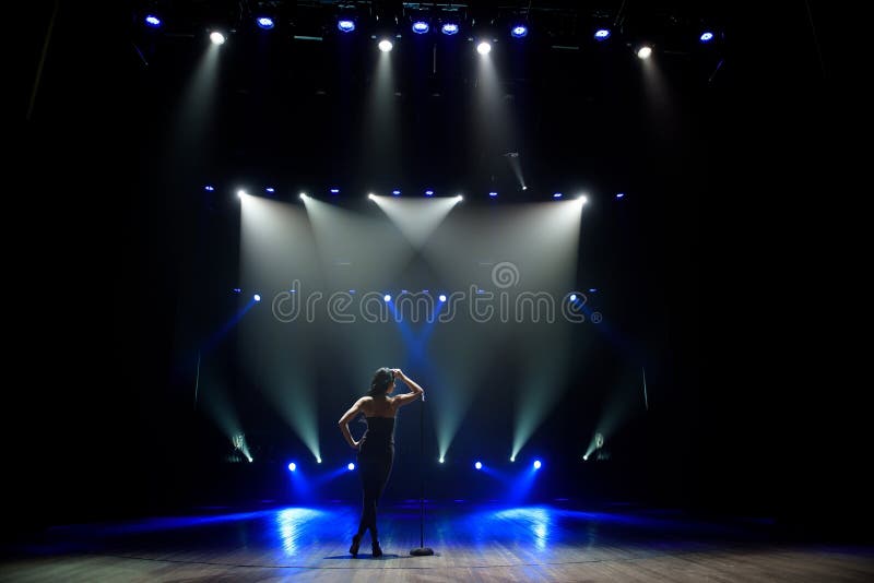 Silhouette of Singer Standing on Stage at Microphone in Night Club ...