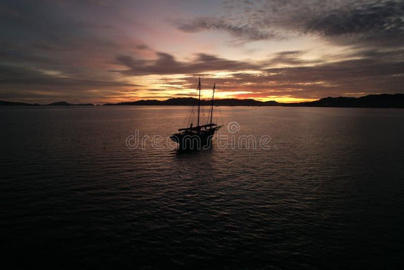 Silhouette of a Single Boat in the Middle of an Ocean at Sunset in ...