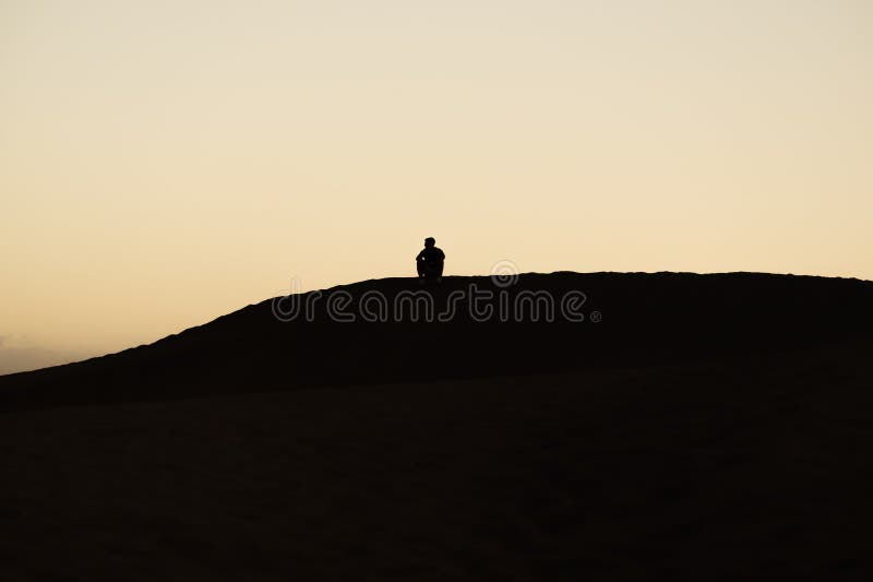 Silhouette of a Single Person Sitting in the Desert Stock Photo - Image ...