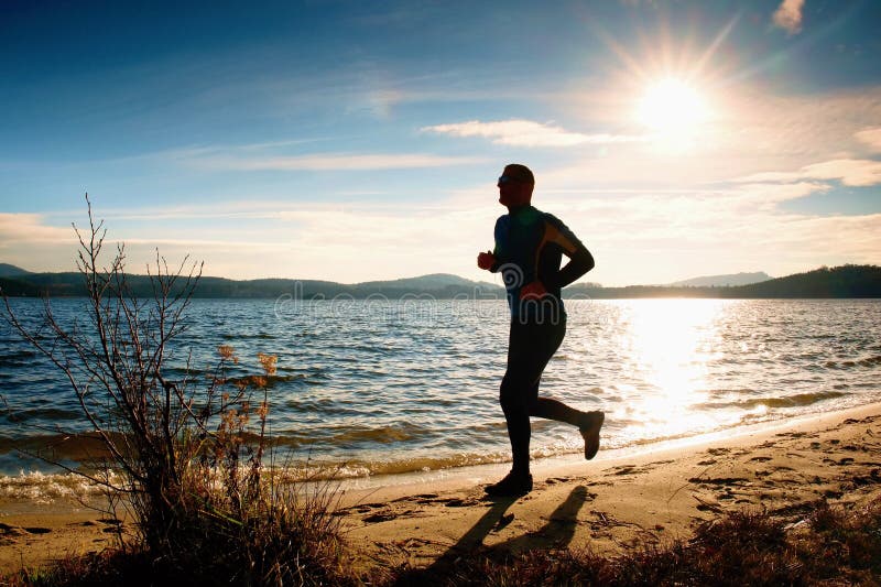 Silhouette of Sport Active Man Running and Exercising on Beach at Busch ...