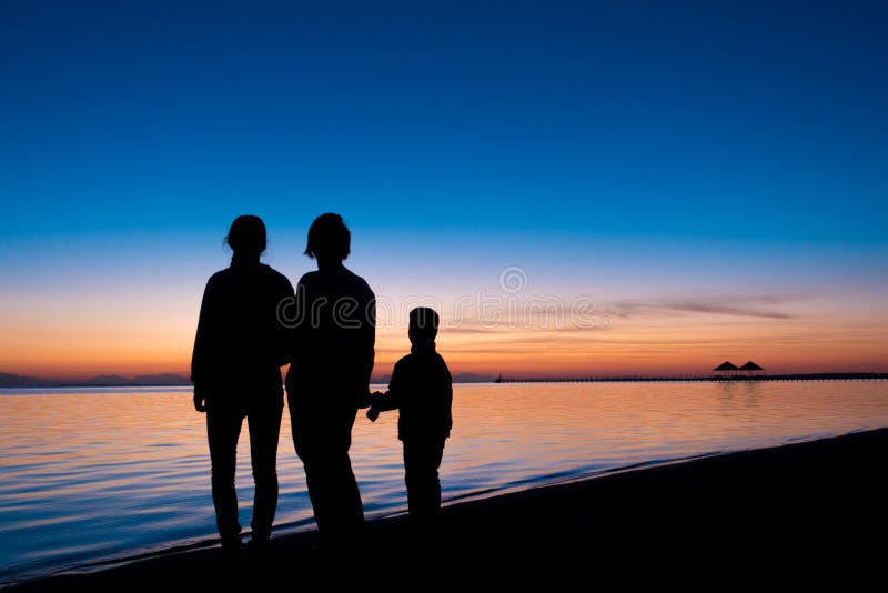 Silhouette of Three People Standing on the Beach in Sunrise Stock Photo ...