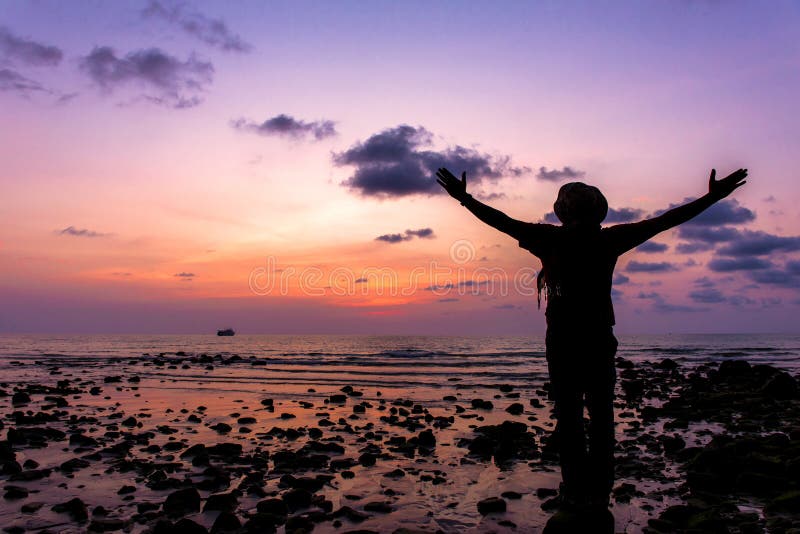 Silhouette of Traveler with Hands Up in the Sunset on the Ocean Stock ...