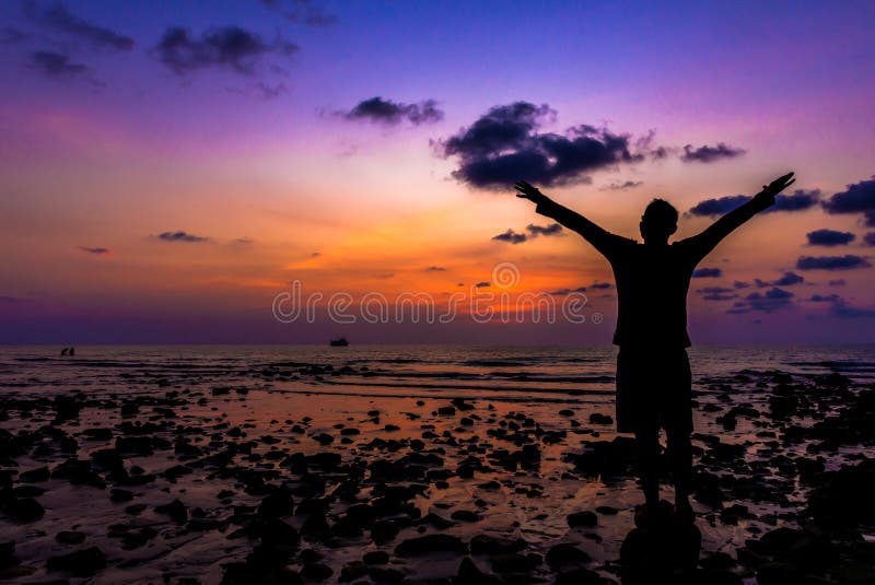 Silhouette of Traveler with Hands Up in the Sunset on the Ocean Stock ...