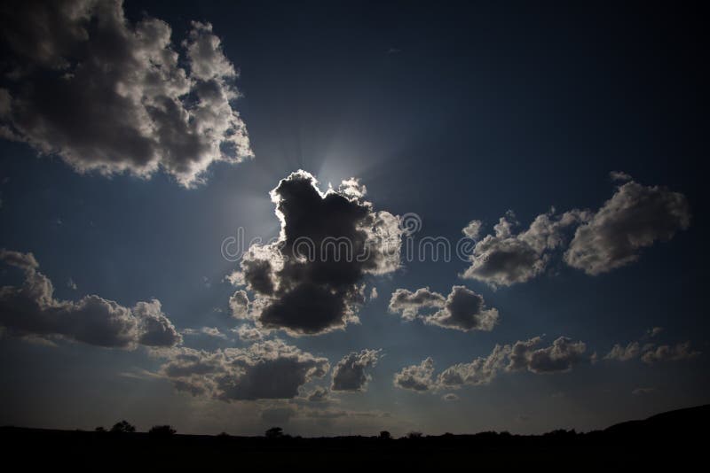 Sun Behind the Glowing Clouds Stock Photo - Image of clouds, silhouette ...
