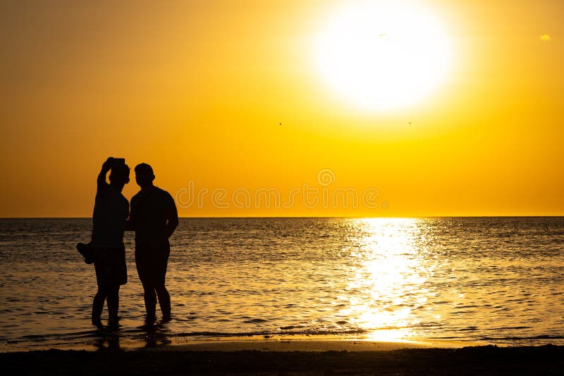 Silhouette of Two Men Taking a Selfie on the Beach at Sunset Stock ...