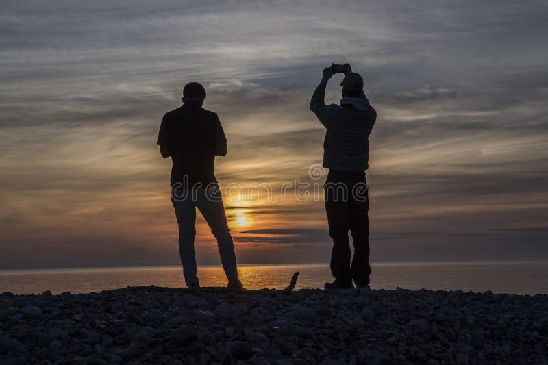 Silhouette of Two Young Men Photographing the Sunset on the Beach Stock ...