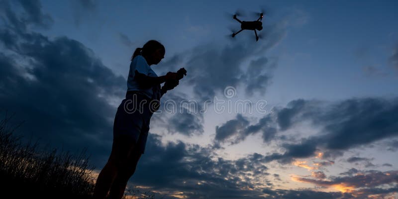 Silhouette of Man Controlling Drones Flying on Sky at Sunset. Stock ...