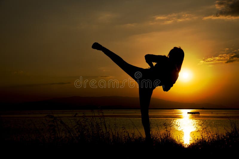 Silhouette of Beautiful Kick Boxing Girl Exercising Kick in the Nature ...