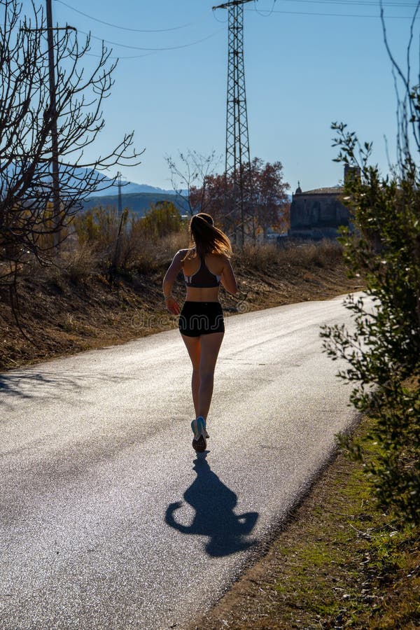 Silhouette of a Young Female Runner Backlit by Dawn Sunlight ...