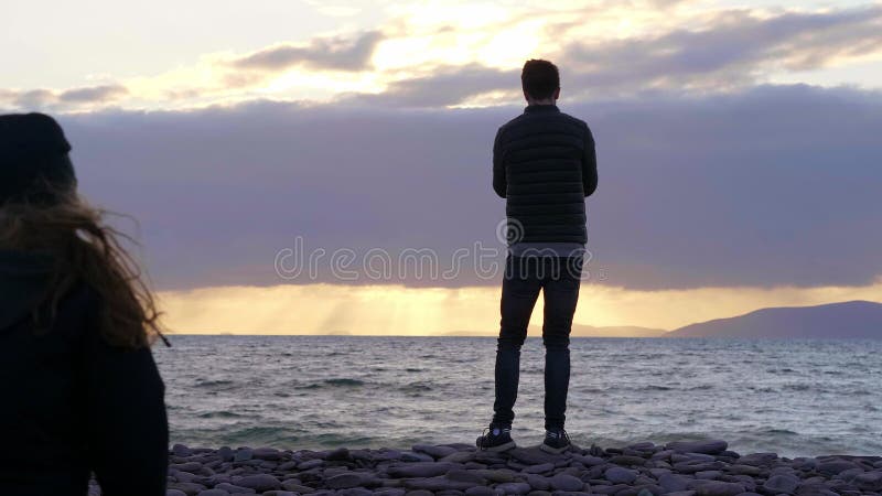 Silhouette of Young Man in the Backlight Standing at the Beach Stock ...