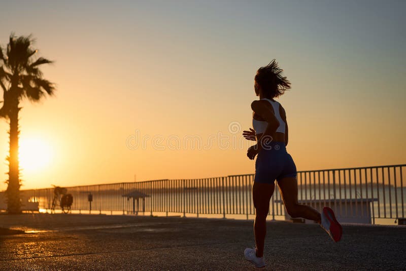 Silhouette of Young Woman Jogging on Shore at Sunrise. Stock Image ...