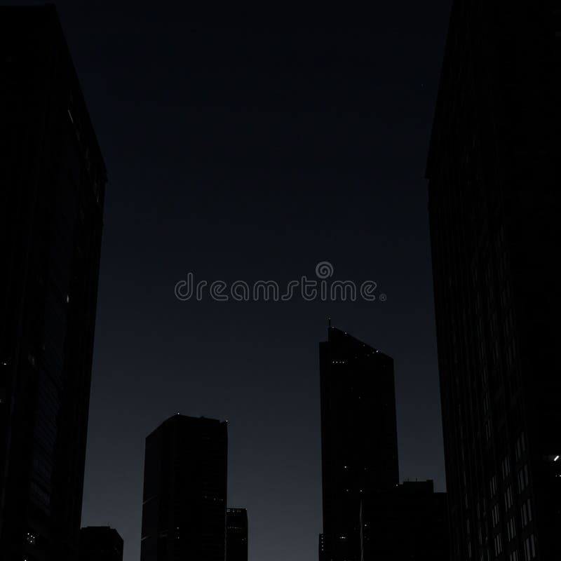 Silhouetted Against a Dimly Lit Sky, Several High-rise Buildings Form a ...