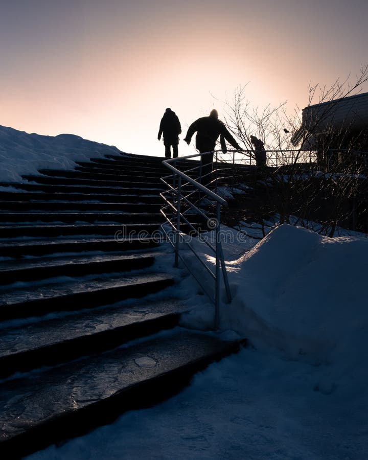 Silhouetted Figures on Snowy Steps at Sunset. Stock Image - Image of ...