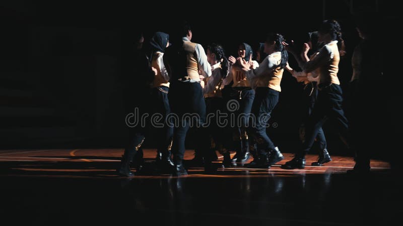 Silhouetted Dancers on a Dark Stage with Dramatic Lighting, Performing ...