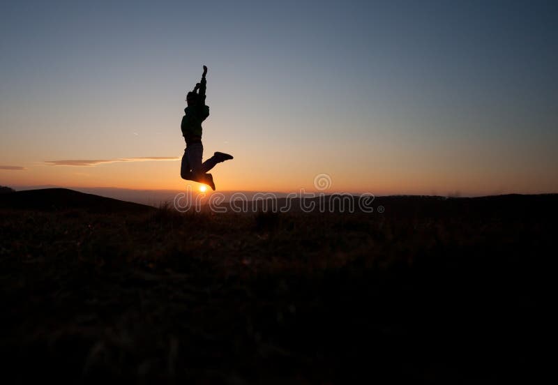 Silhouetted Man Jumping in Sunset Stock Image - Image of arms ...