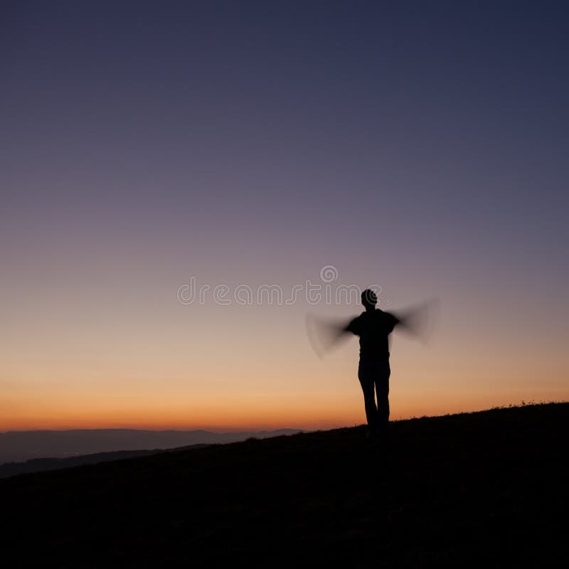Silhouetted Man Waving with Arms in Sunset Stock Photo - Image of ...