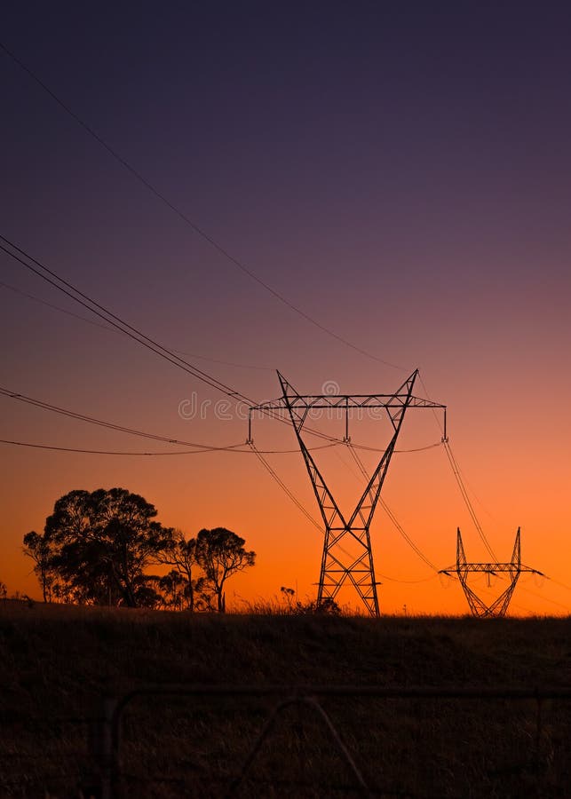 Silhouetted Power Line Pylons Against a Sunset Stock Photo - Image of ...