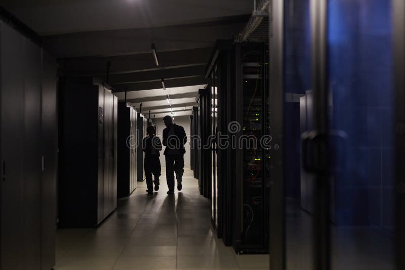 Silhouetted Technicians Working in Server Room Corridor Stock Image ...