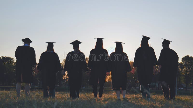 Silhouettes of College Graduates Standing in a Meadow. Stock Image ...