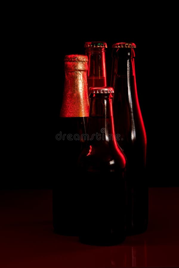 Silhouettes of Four Beer Bottles on a Black Background and Lit with Red ...