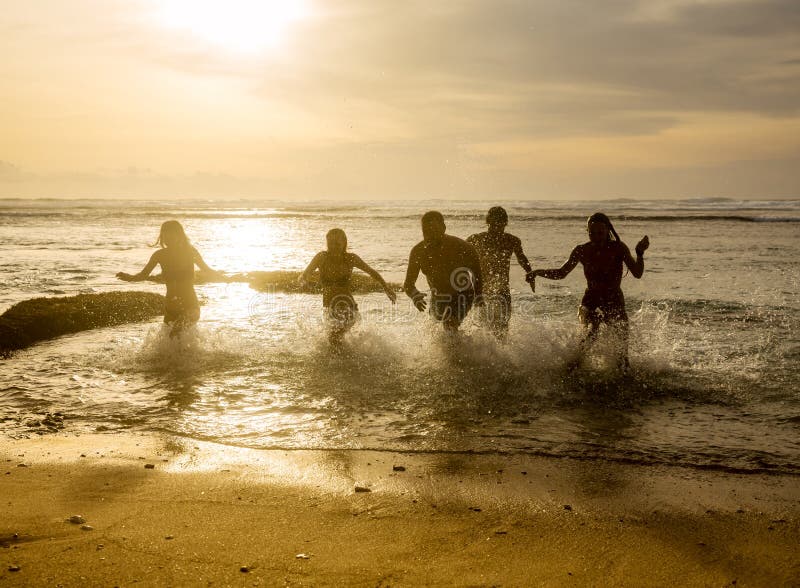 Silhouettes of Friends Running Out of the Ocean Stock Image - Image of ...