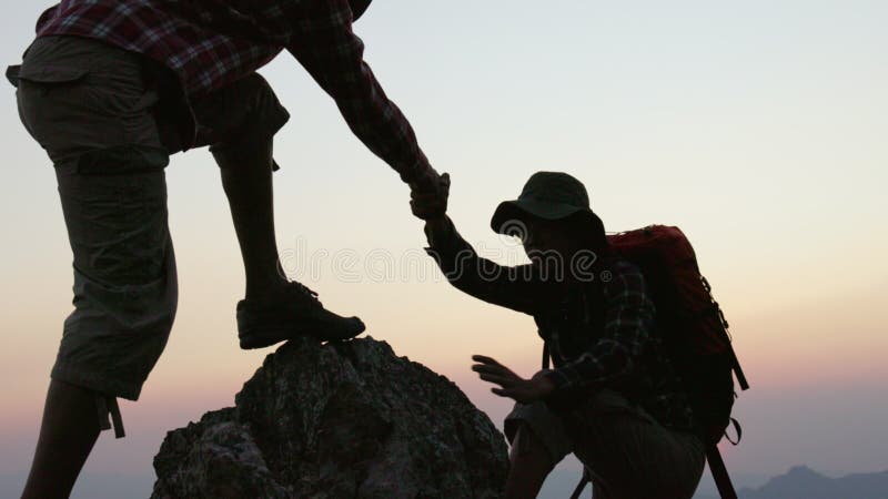 Silhouettes a Group of Climbing on Mountain and Helping. Help and ...