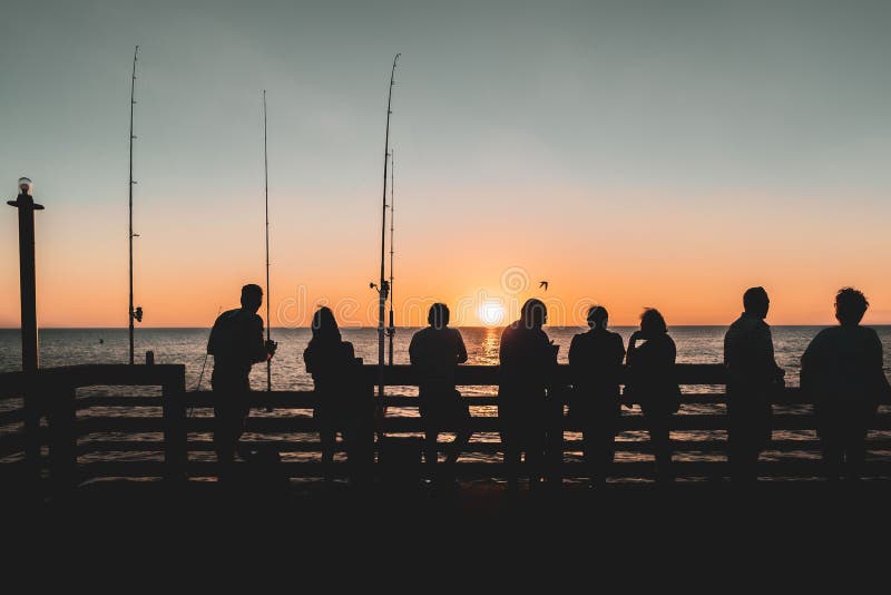 Silhouettes of a Group of People on a Pier, Enjoying the Beautiful ...