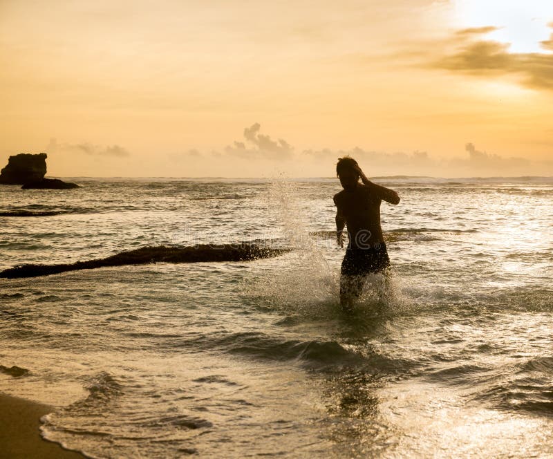 Silhouettes of Man Running Out of Ocean Stock Image - Image of ...