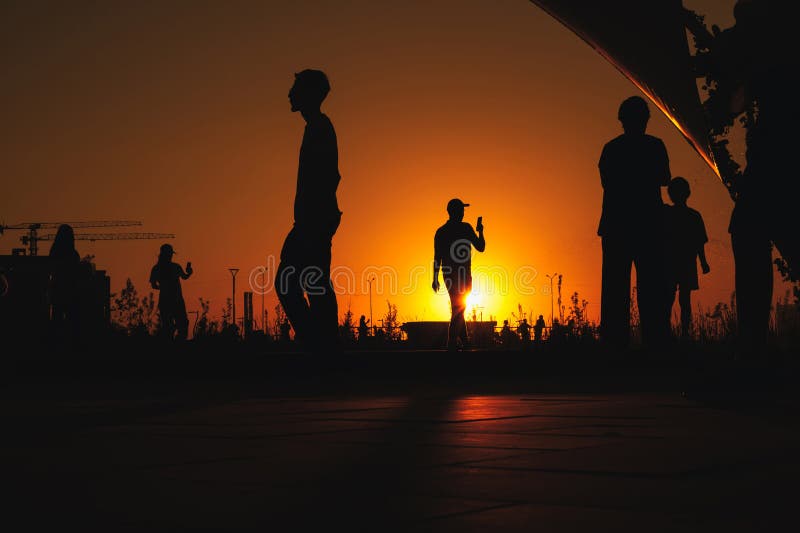 Silhouettes of People Having Fun in a Public Park at Sunset Stock Image ...