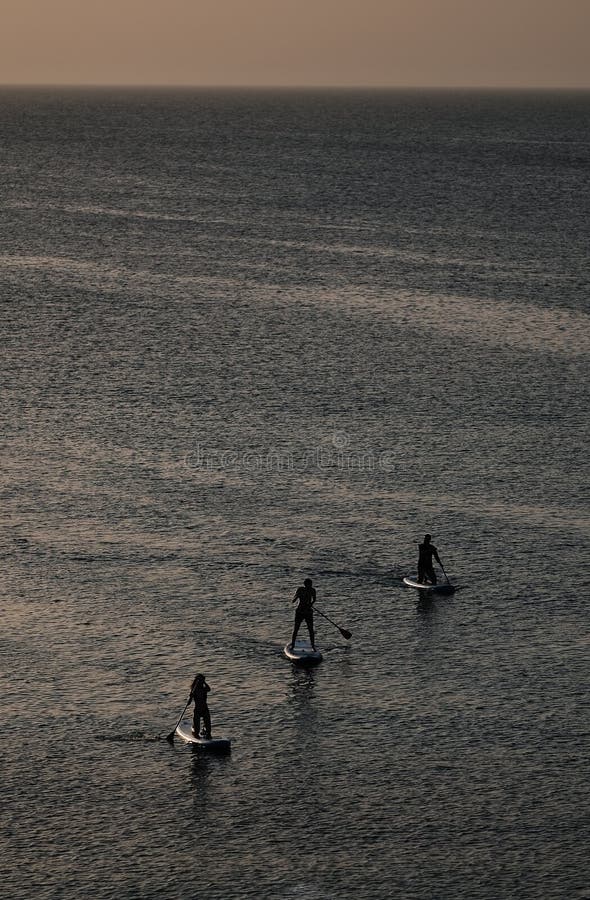 Silhouettes of People Supping on the Sea at Sunset. Stock Photo - Image ...